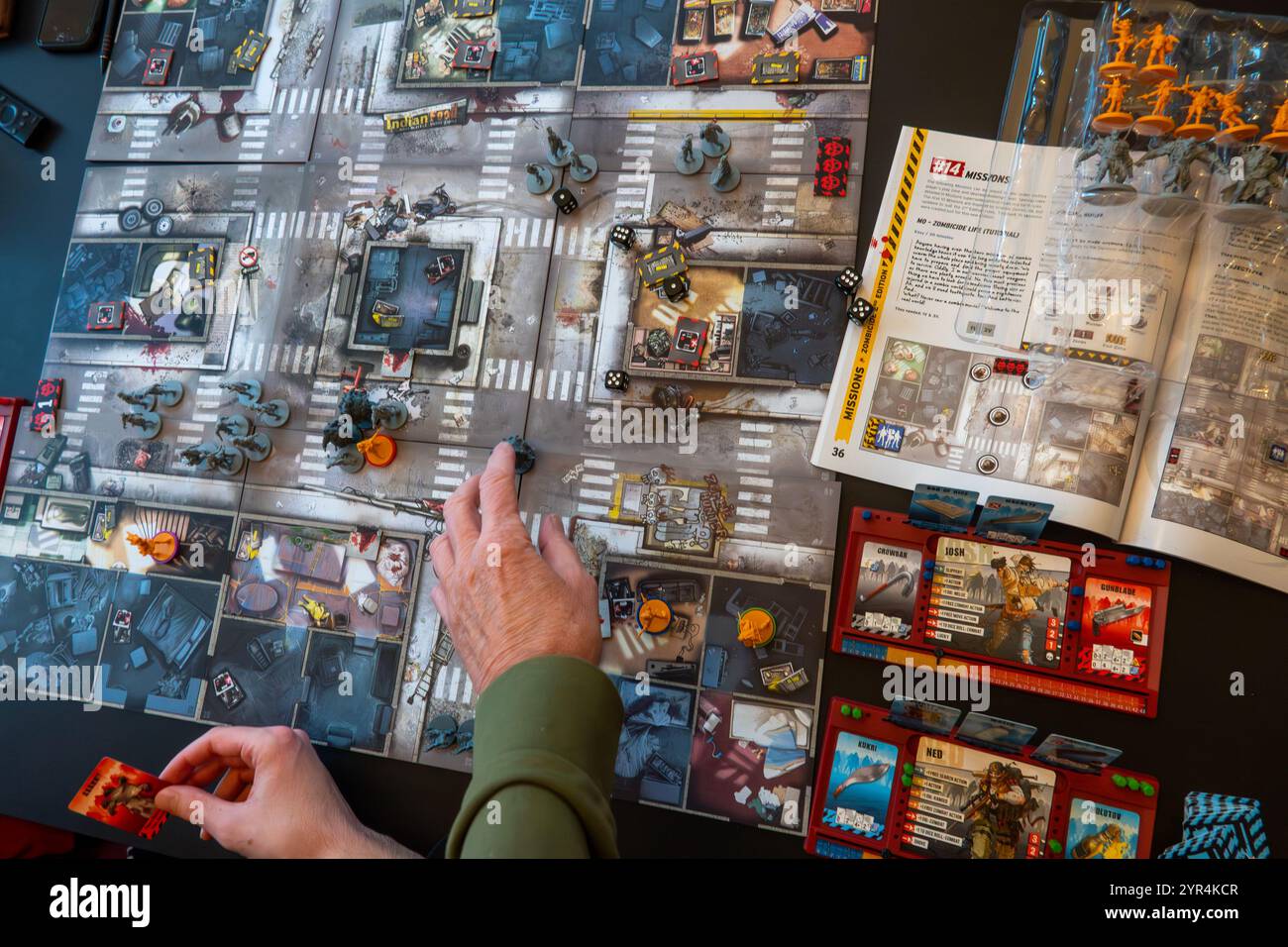Hands of people playing the popular adventure board game zombicide ...