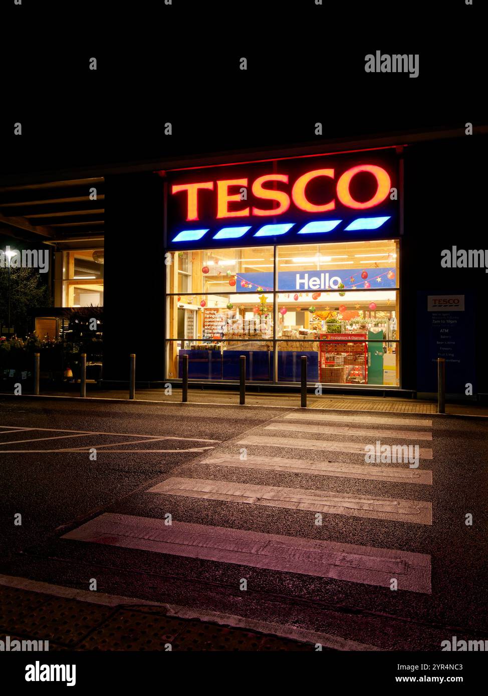 Tesco supermarket signage and lighting from the interior illuminates ...