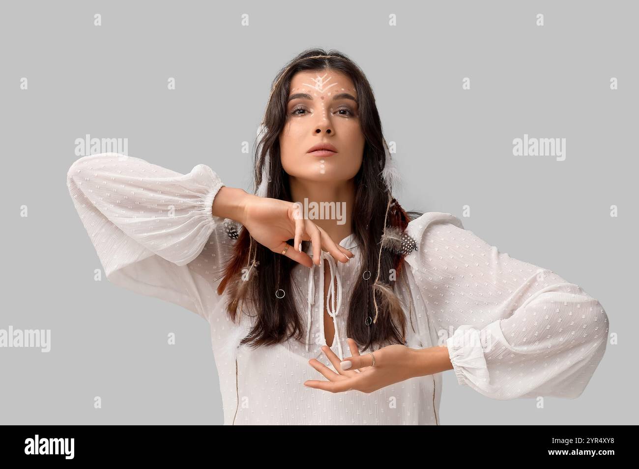 Beautiful female shaman on light background Stock Photo - Alamy