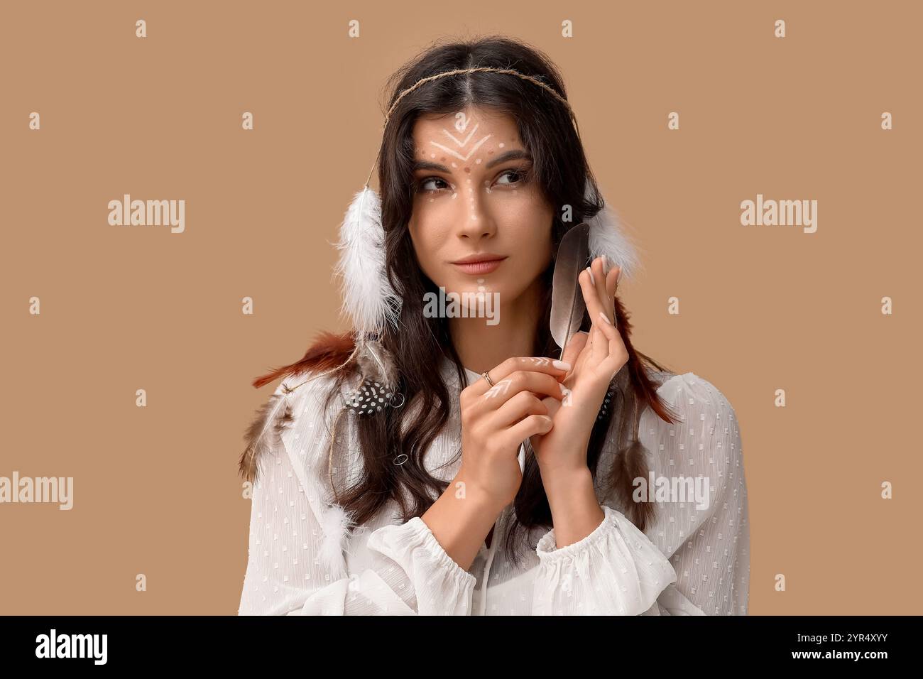 Beautiful female shaman on beige background Stock Photo - Alamy