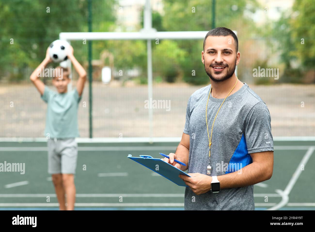 Father doing notes while his son playing soccer Stock Photo - Alamy