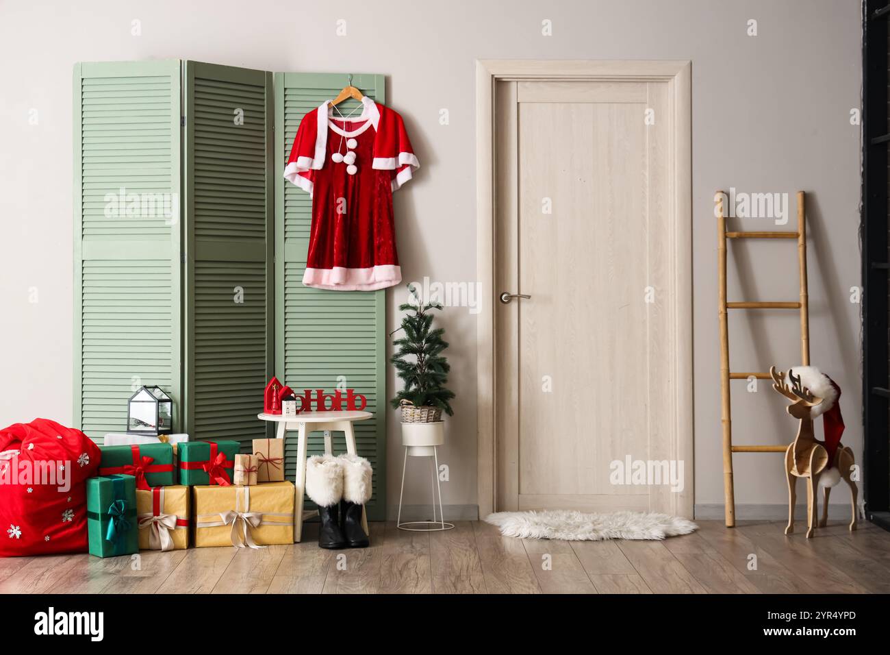 Interior of hall with Santa costume on folding screen, door and ...