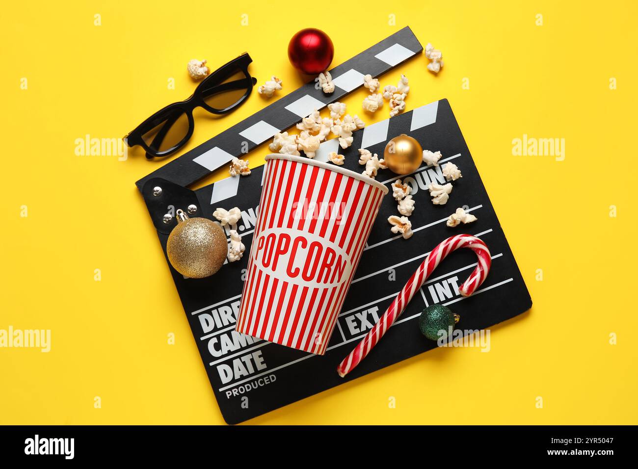 Popcorn, movie clapper, 3D glasses and decorations on yellow background ...