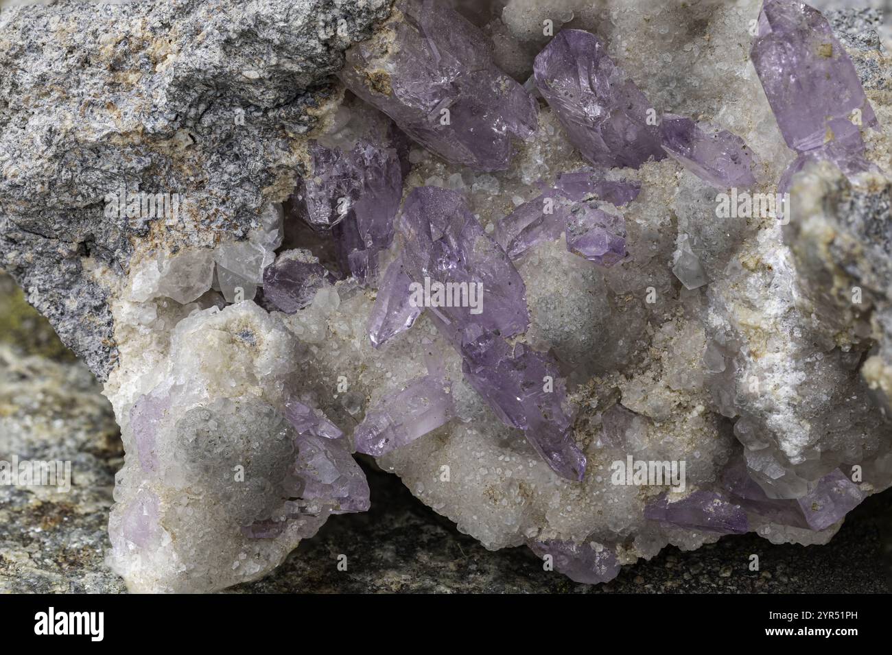 Cluster of sharp, purple amethyst crystals set against a contrasting ...
