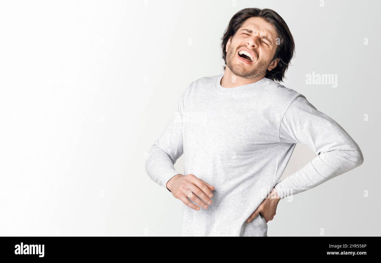Sharp back pain. Man suffering from pain and screams Stock Photo - Alamy