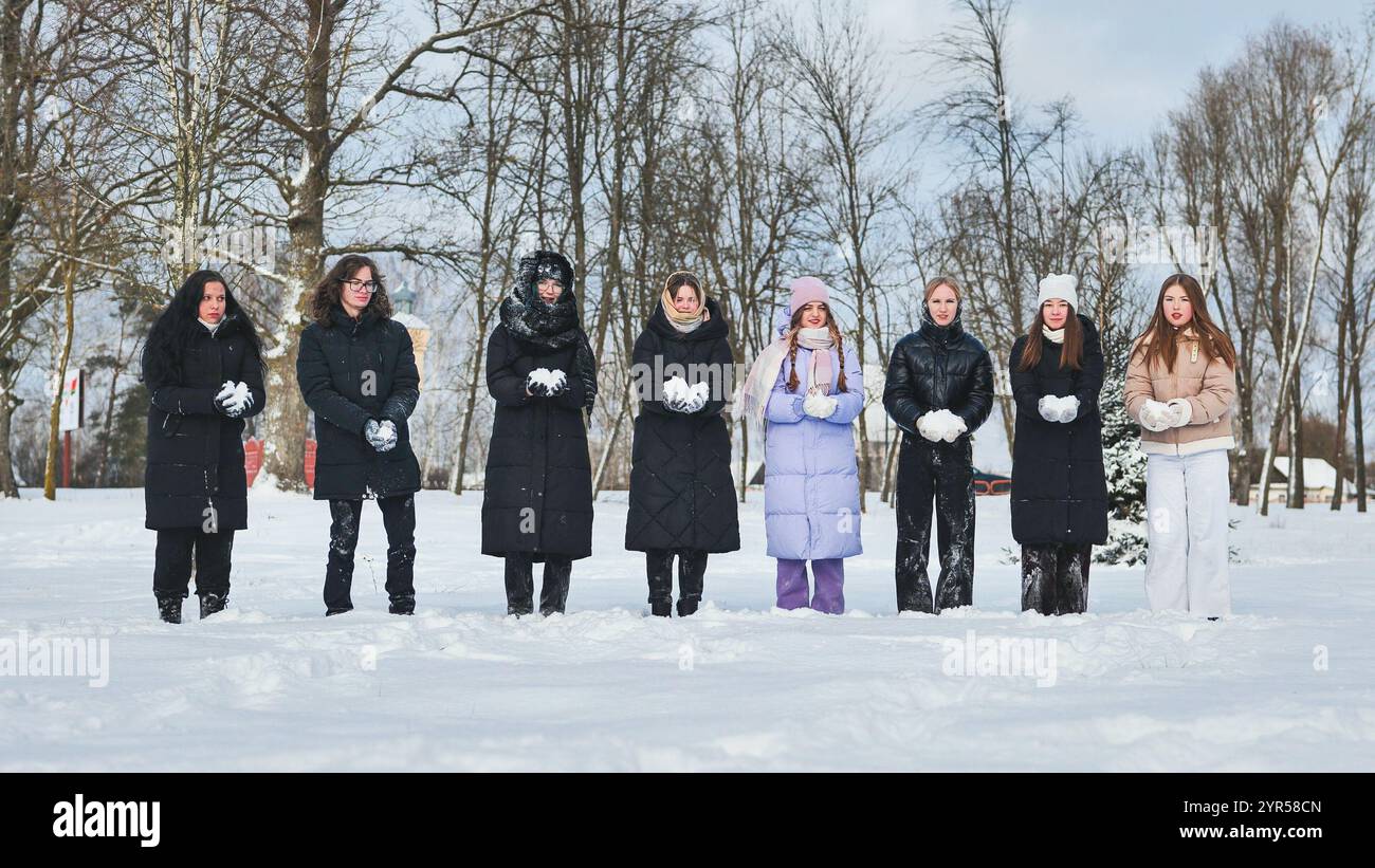 Group of schoolgirls holding snowballs, enjoying a winter day in a ...
