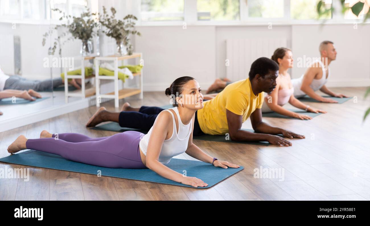 Asian woman performing Sphinx Pose during group yoga training Stock ...