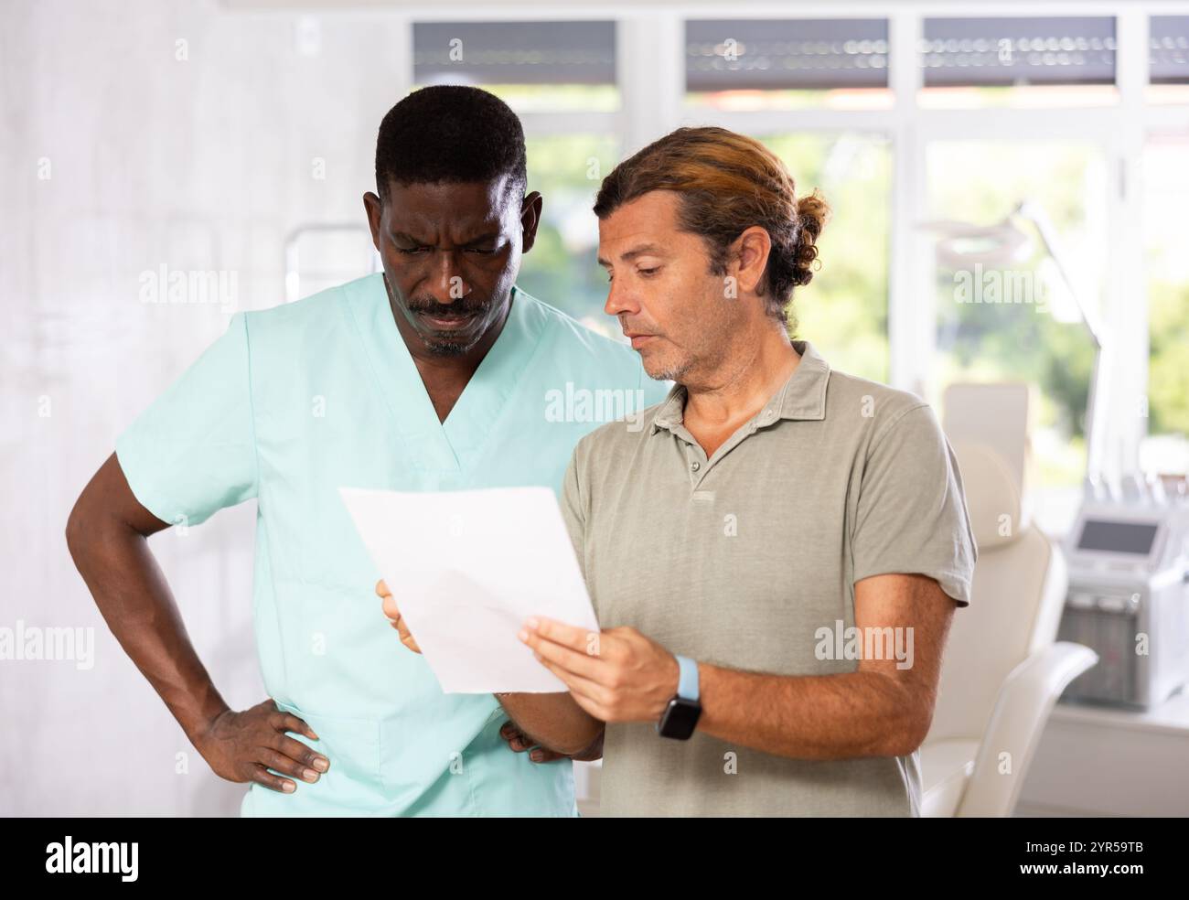 African doctor shows client papers for signing before rejuvenating ...