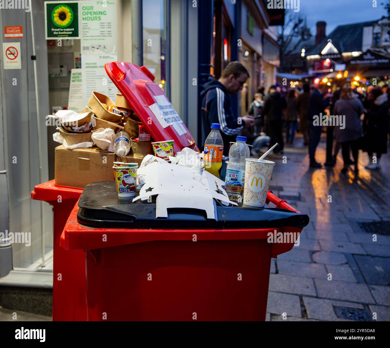 Overflowing trash/rubbish bin with food containers and drinks discarded ...