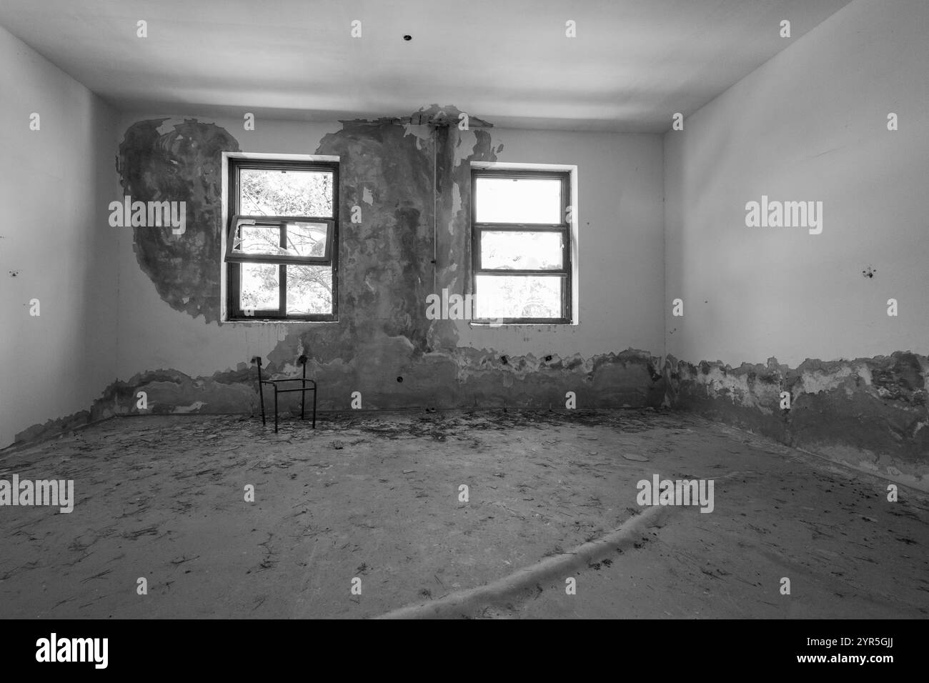 Abandoned room with two windows and crumbling walls, empty atmosphere ...