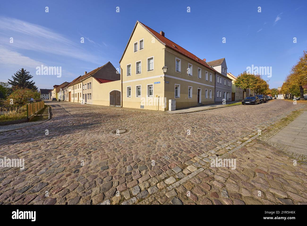 Residential building, cobblestone pavement, blue sky with cirrostratus ...