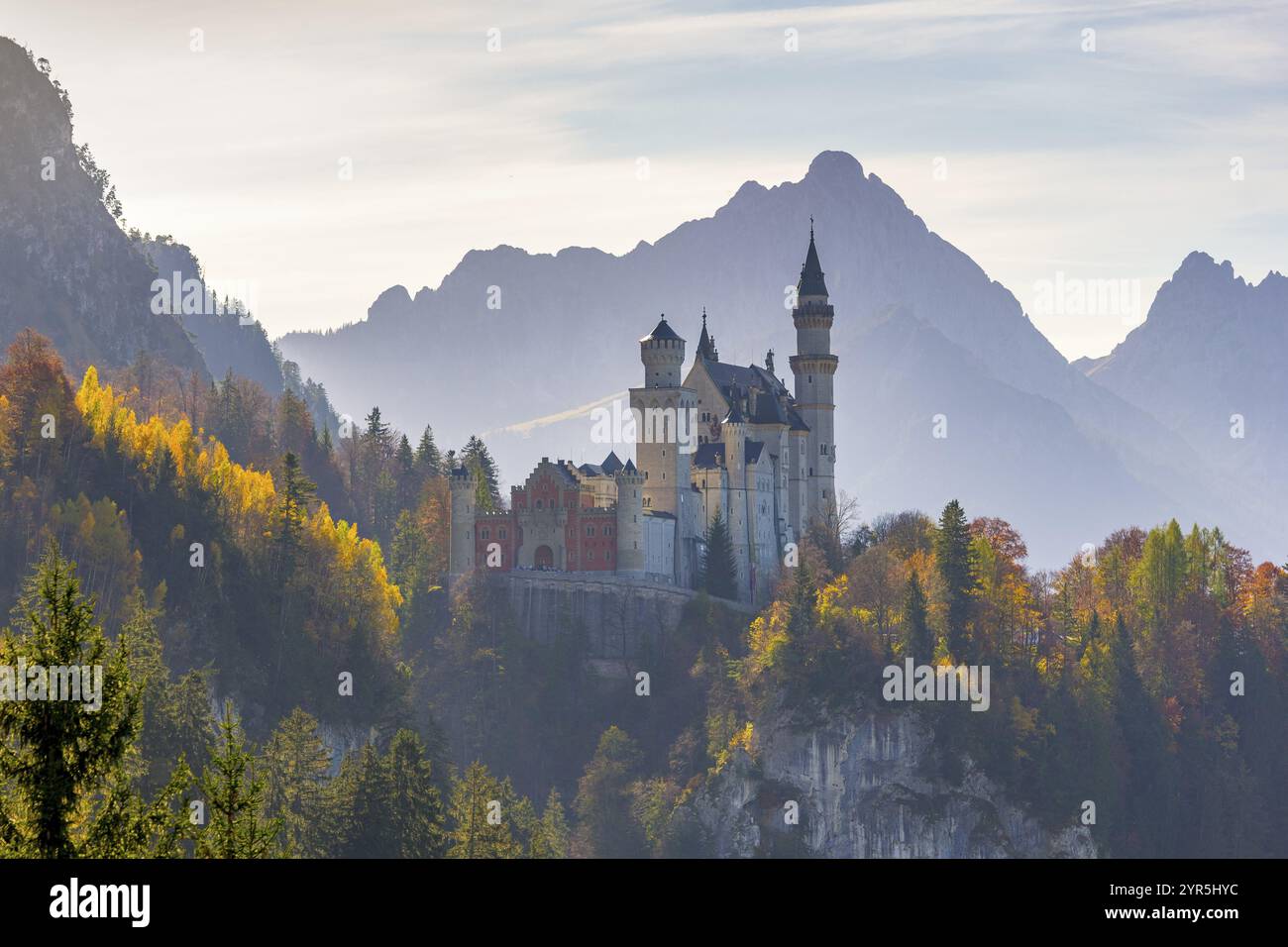Fairytale Neuschwanstein Castle surrounded by autumnal trees against a ...