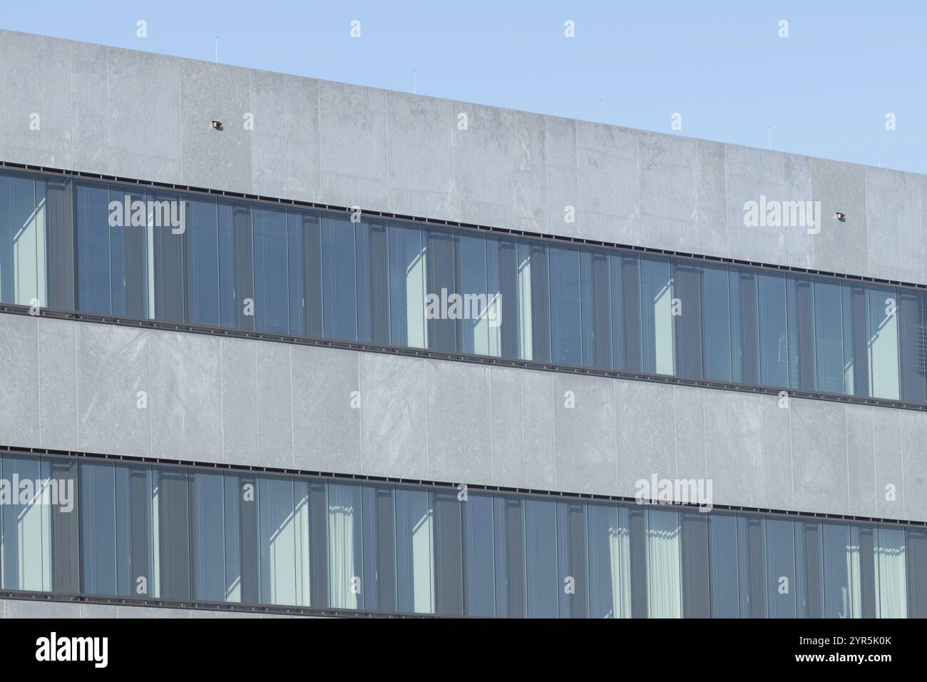 Modern concrete building with rows of reflective glass windows Stock ...