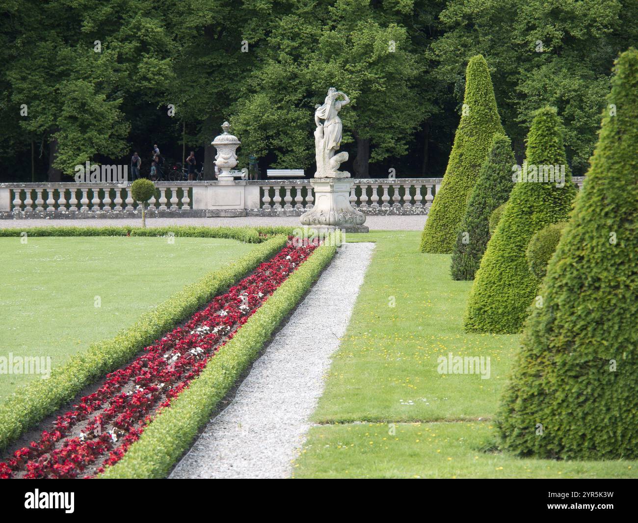 Elaborate baroque garden with statue and blooming flower beds along ...