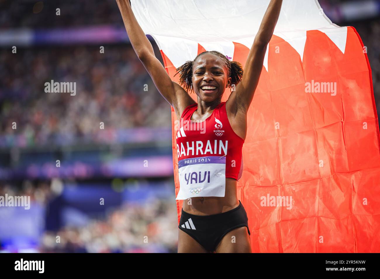Winfred Yavi celebrating her medal with her country's flag at the Paris ...