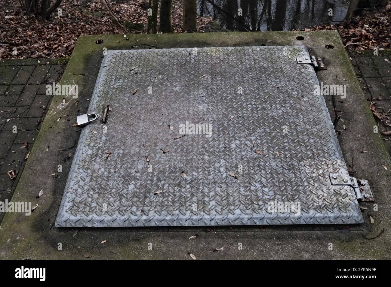 Square metal hatch with textured surface in an outdoor setting ...