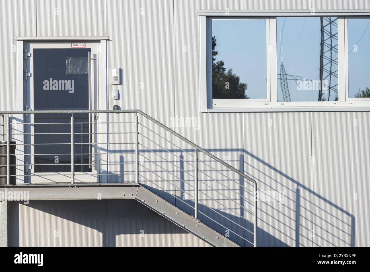 Metal facade of a modern industrial building with door and stairway ...