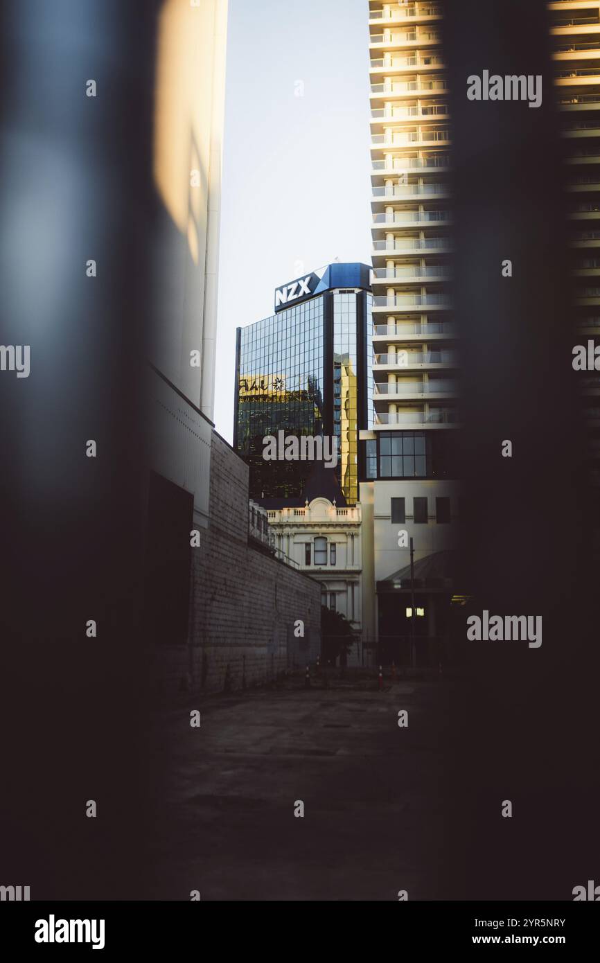 View between buildings of a modern glass skyscraper labelled NZX, new ...