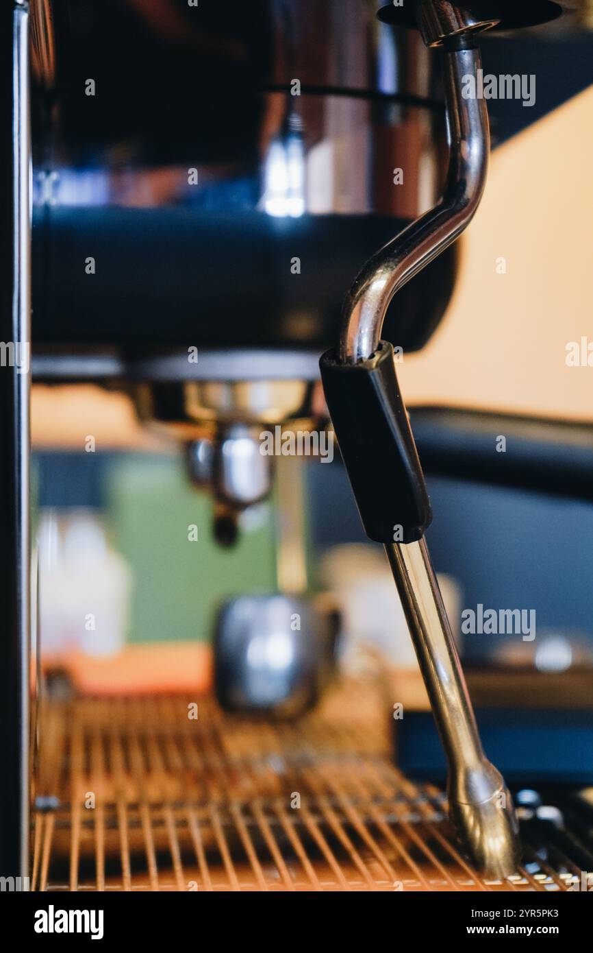 A detailed view of the coffee machine reveals its polished chrome ...