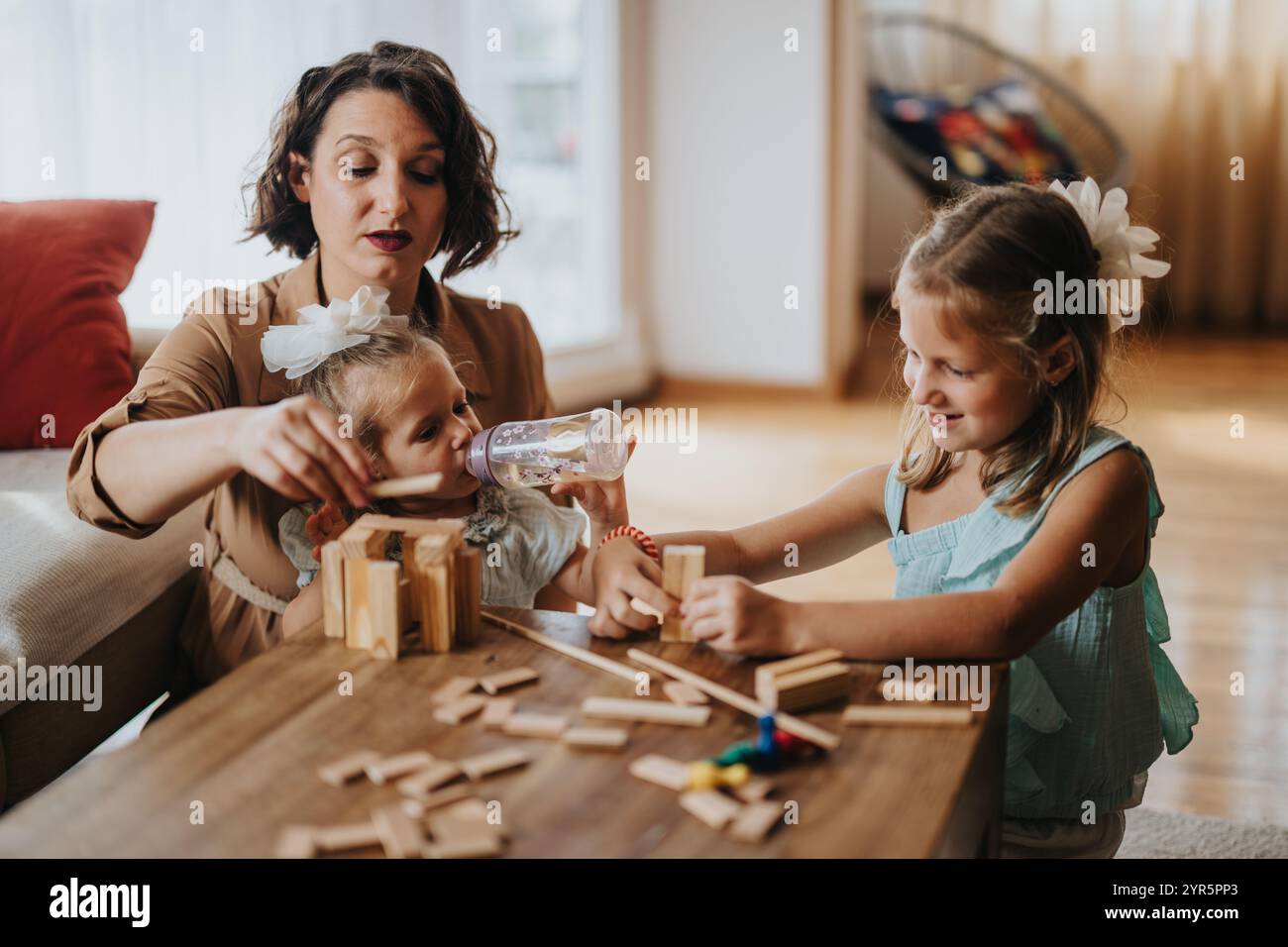 Mother and daughters enjoying playful bonding with building blocks Stock Photo - Alamy