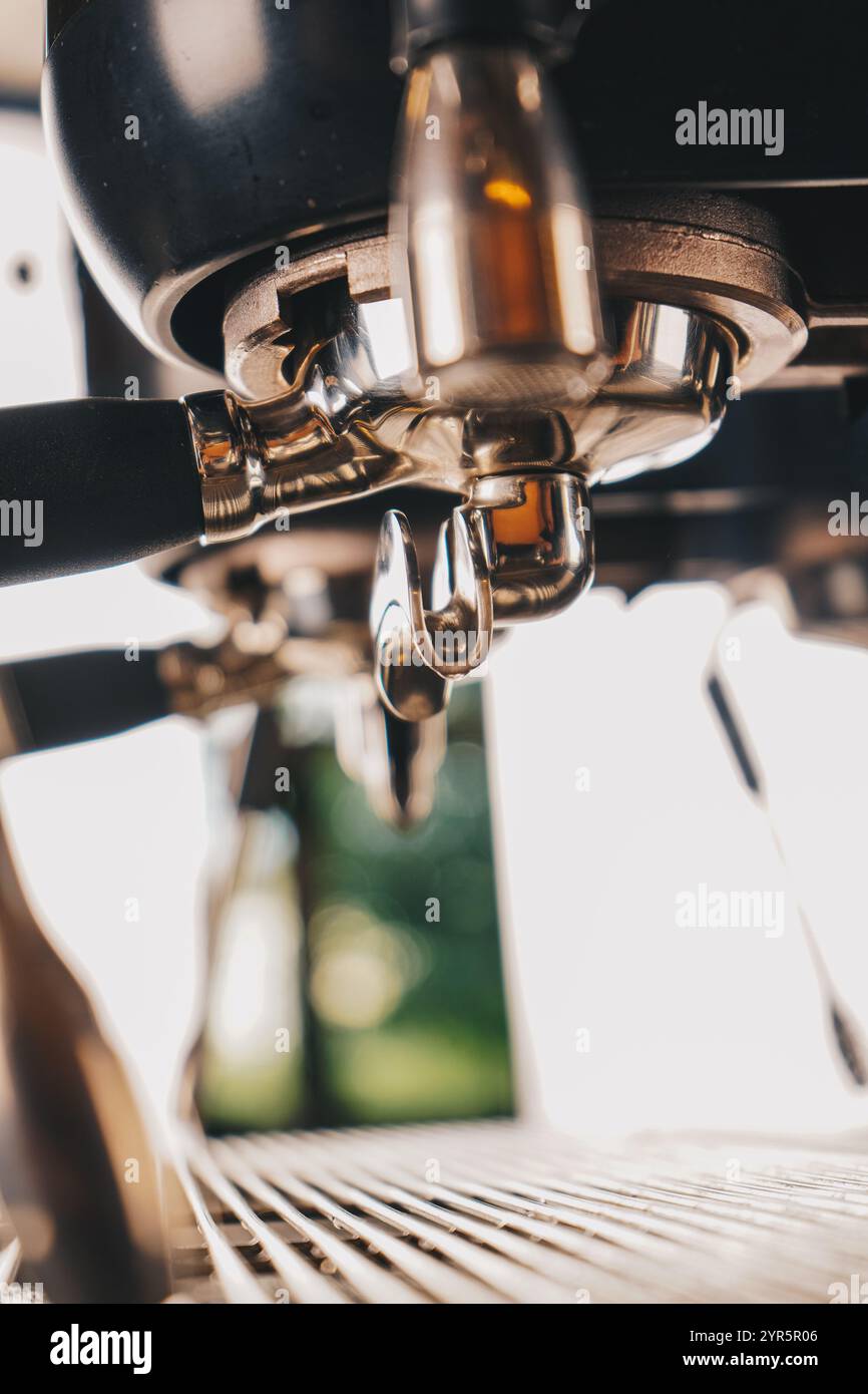 The coffee machine stands tall in focus, its intricate knobs and shiny ...