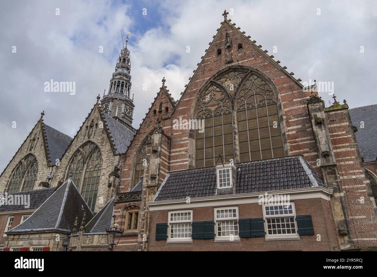 Gothic church with impressive windows and towers under a cloudy sky ...