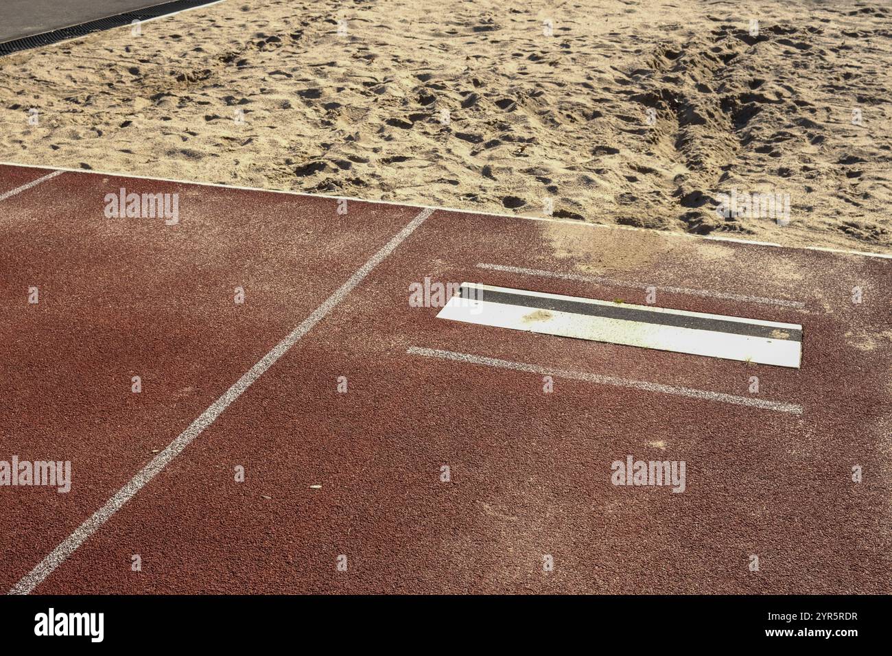 Jumping board of a long jump facility with sand pit Stock Photo - Alamy