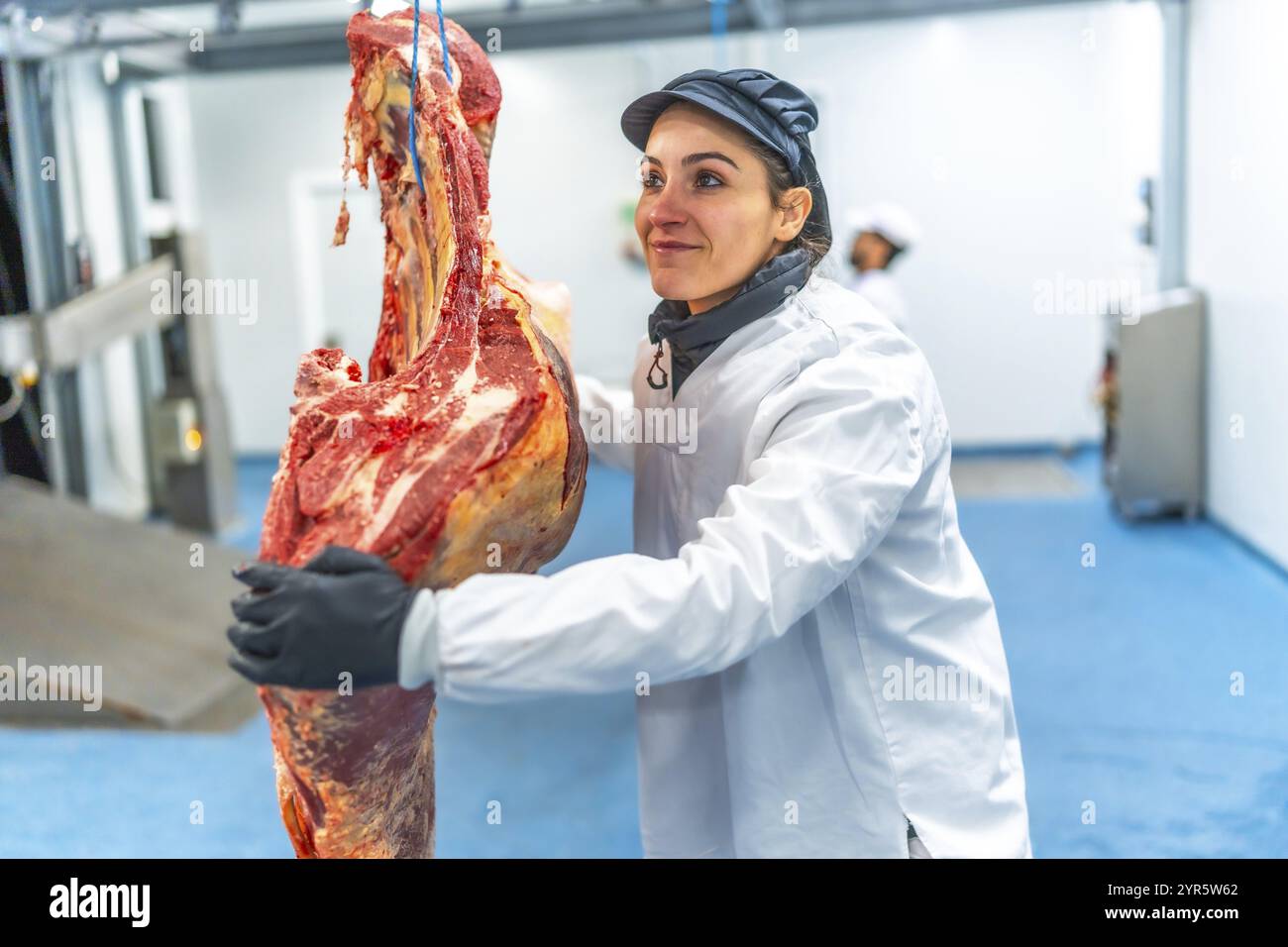 Caucasian adult woman unloading meat from truck in a cold storage room ...