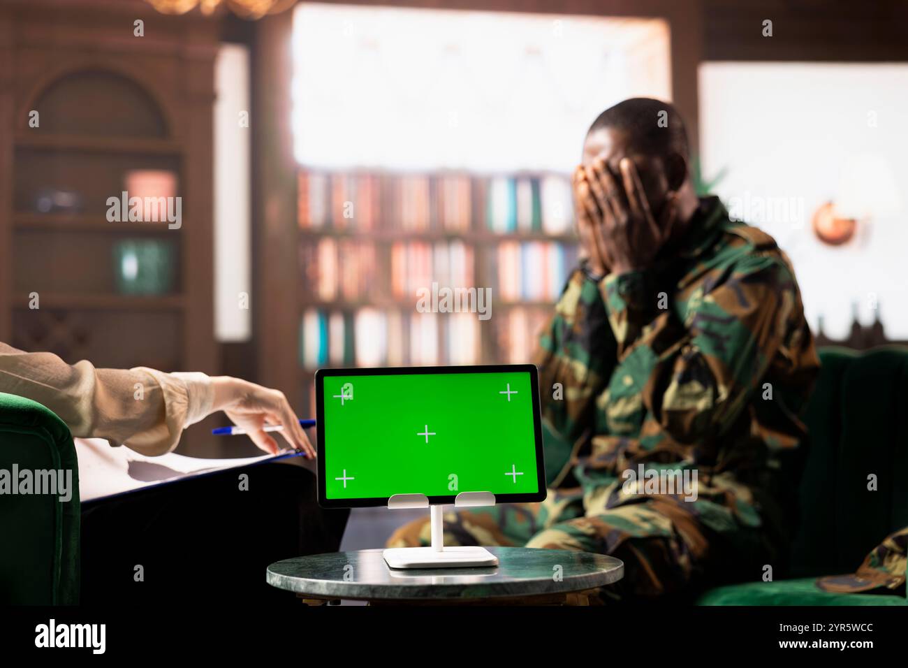 Black army soldier crying at therapy session next to chroma key screen ...