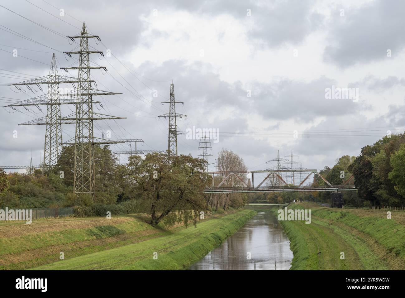 Sewer and high-voltage pylons in a green industrial landscape Stock ...