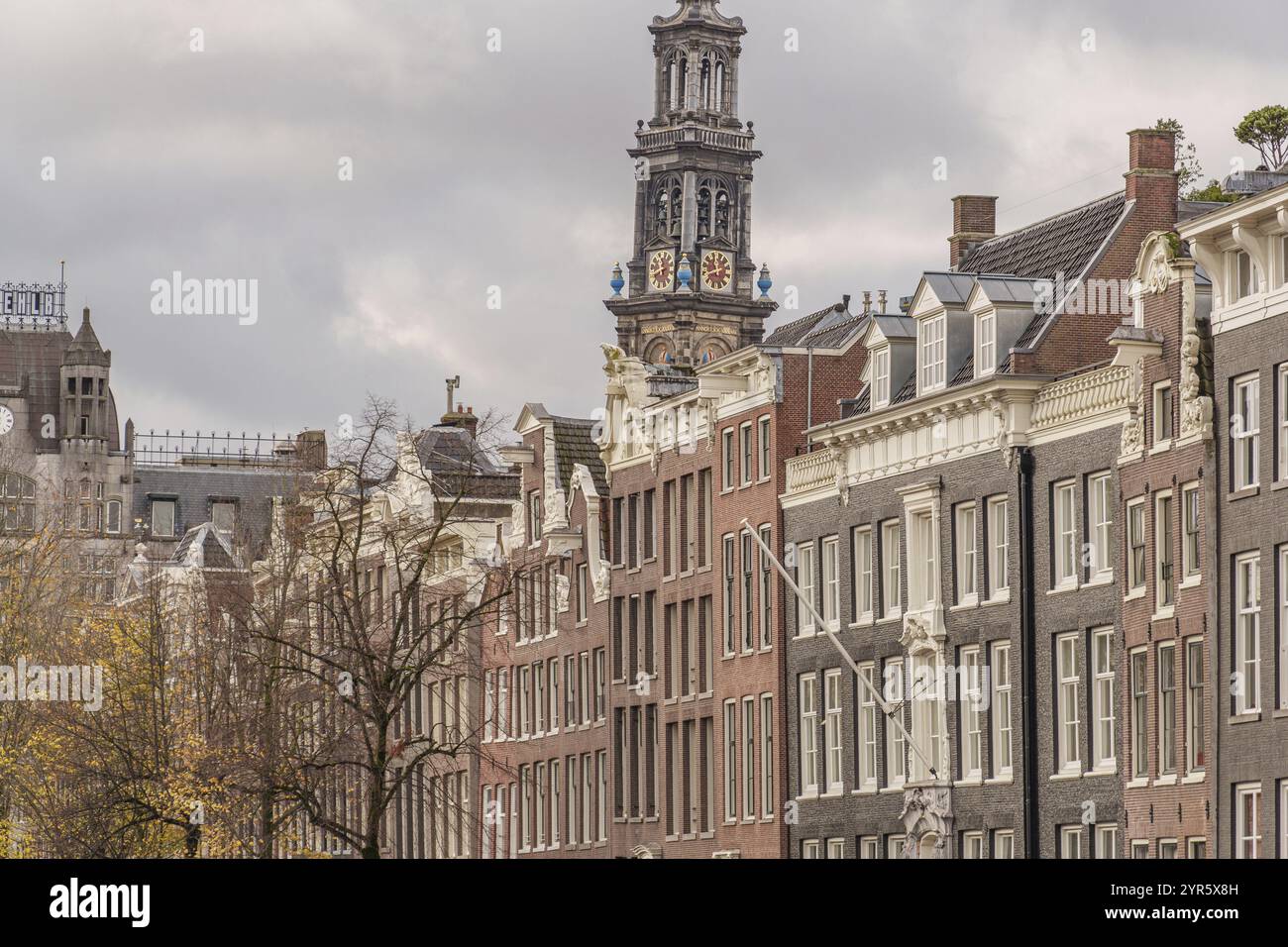 Traditional houses and a tall bell tower under a cloudy sky, Amsterdam ...