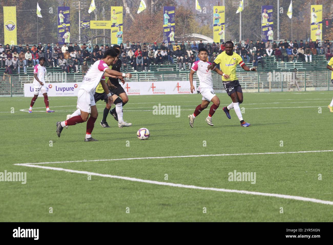 Intense football match with players in motion, focusing on the ball on ...