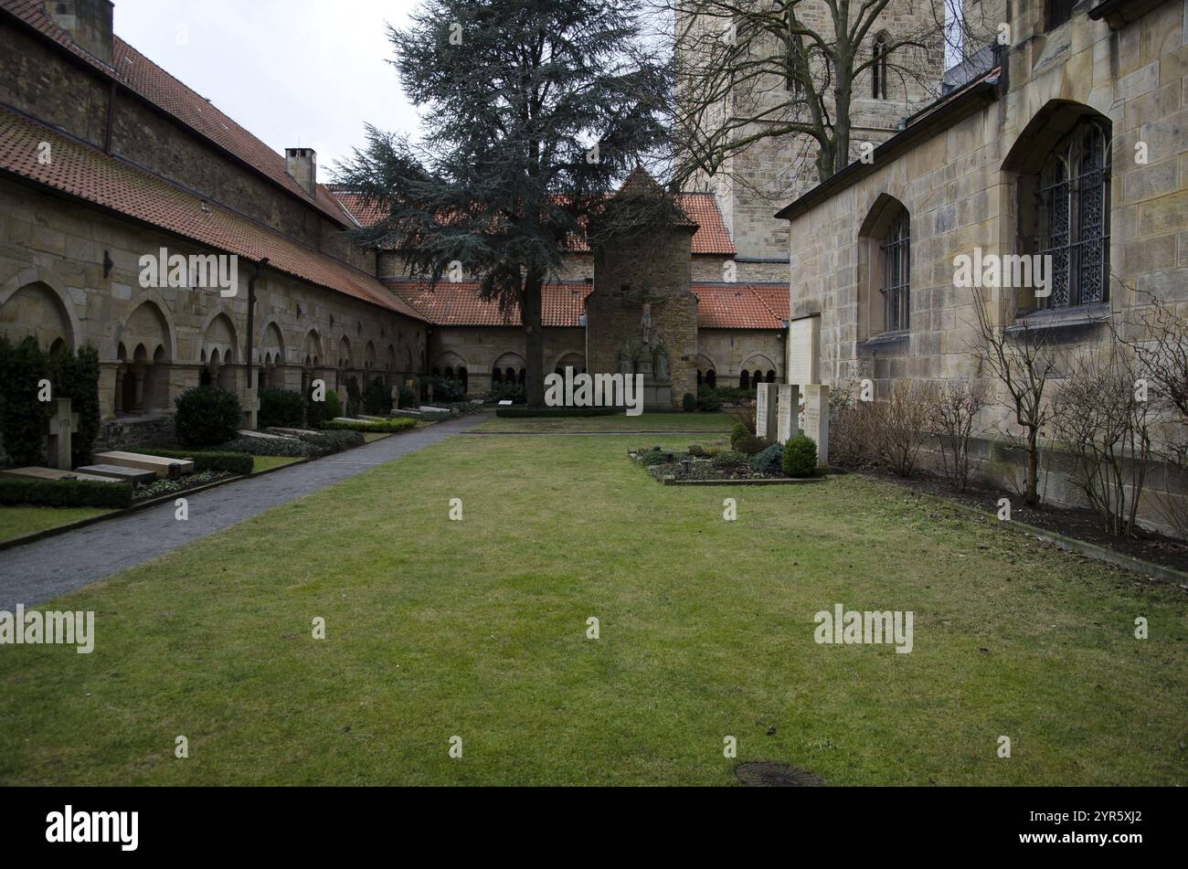 A quiet monastery courtyard with manicured lawns and stone walls ...