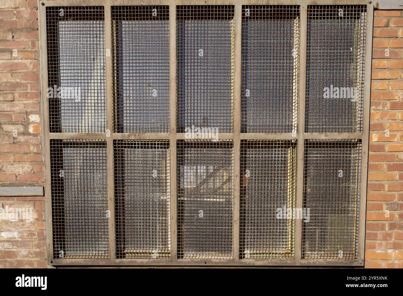 A metal grid structure integrated into a brick wall with an industrial ...