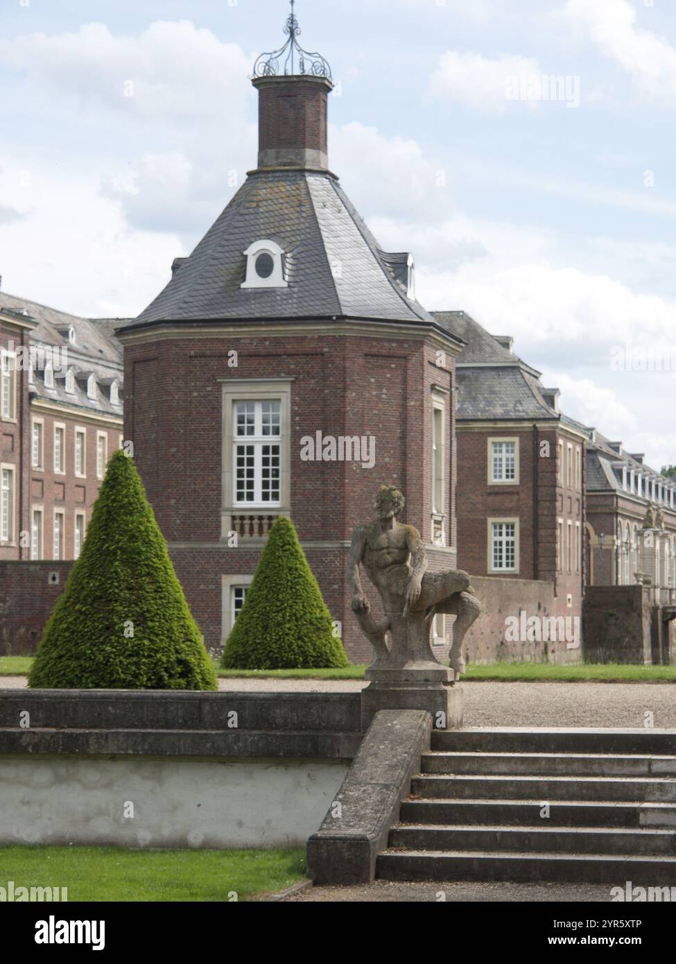 Historic brick manor house with classical sculpture in the front garden ...