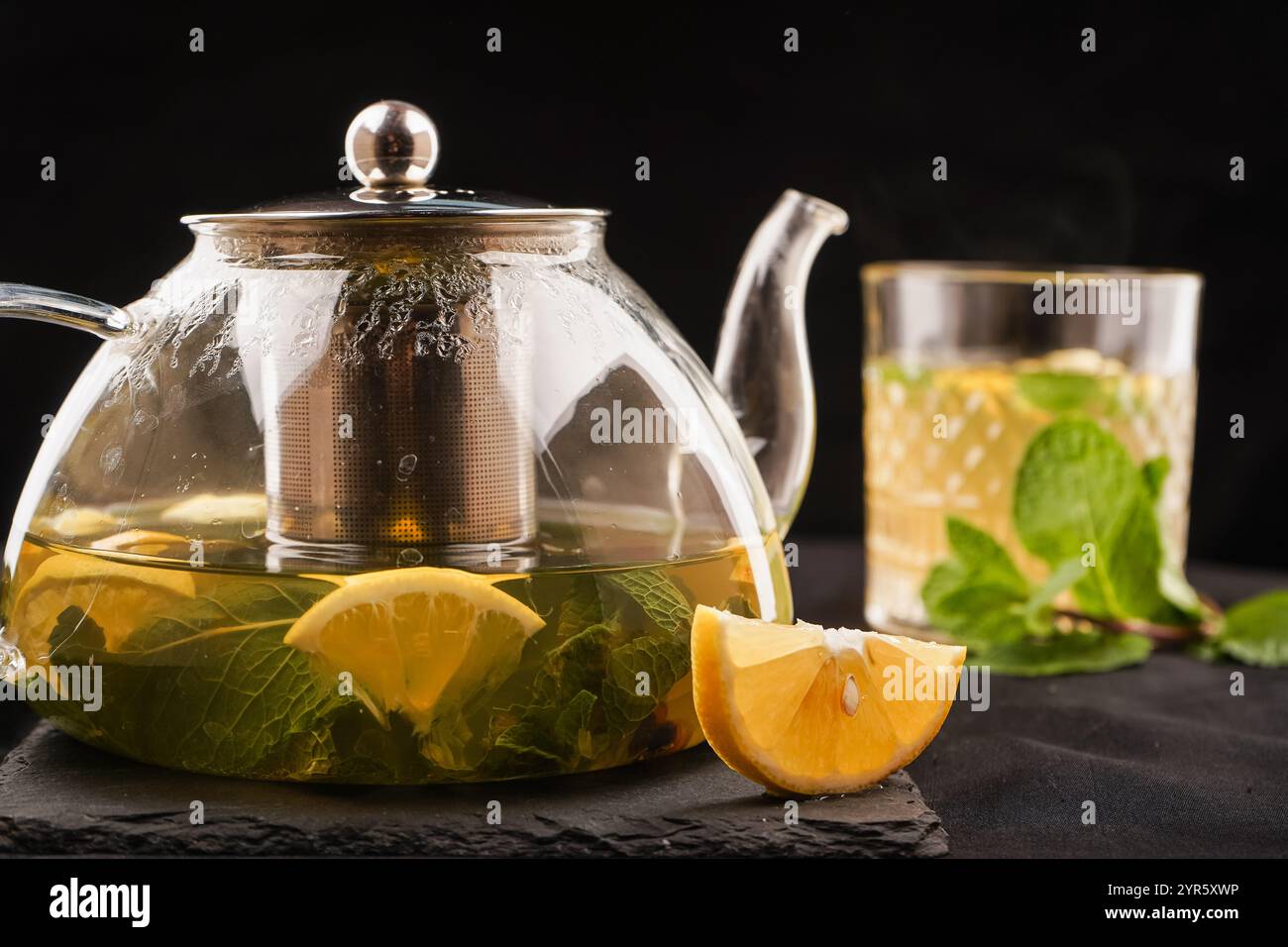 The process of brewing black tea with herbs, glass teapot with black ...