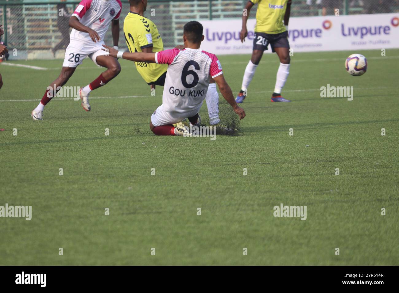 Player in a white jersey executes a slide tackle during an intense ...