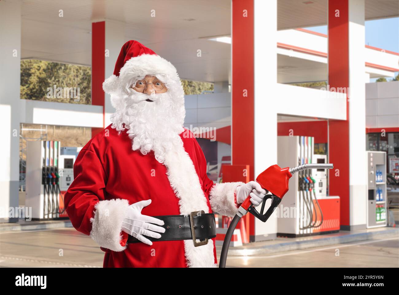 Santa Claus holding a fuel injection nozzle at a petrol station Stock ...