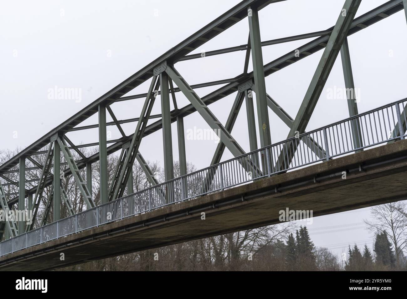 A steel truss bridge spanning an area with trees visible in the ...