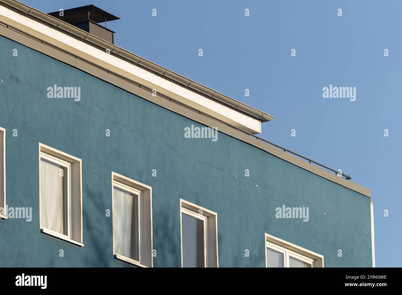 A modern building facade with turquoise walls and several windows Stock ...