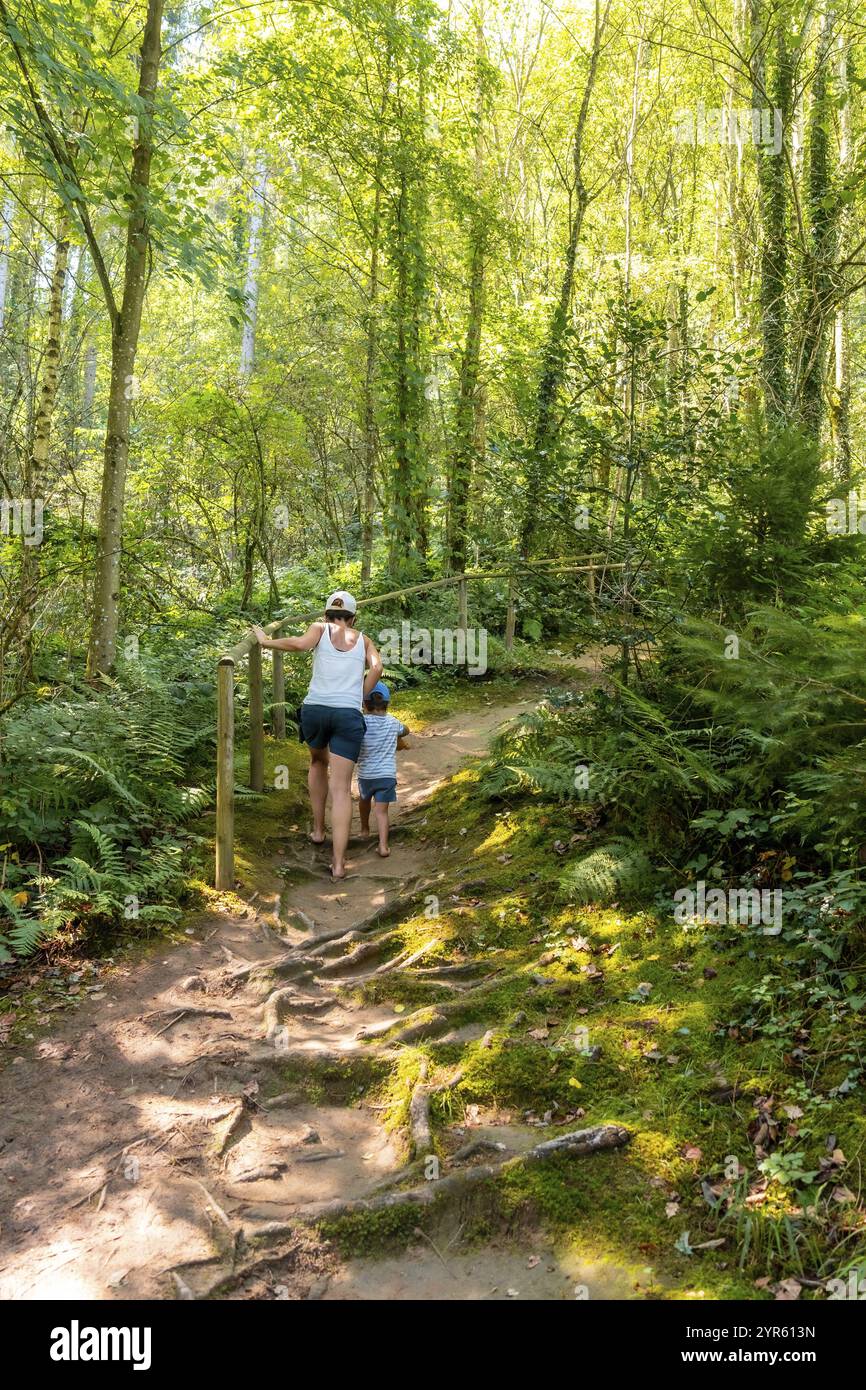 Barefoot mother and son walking in a sensory park to enjoy nature and ...