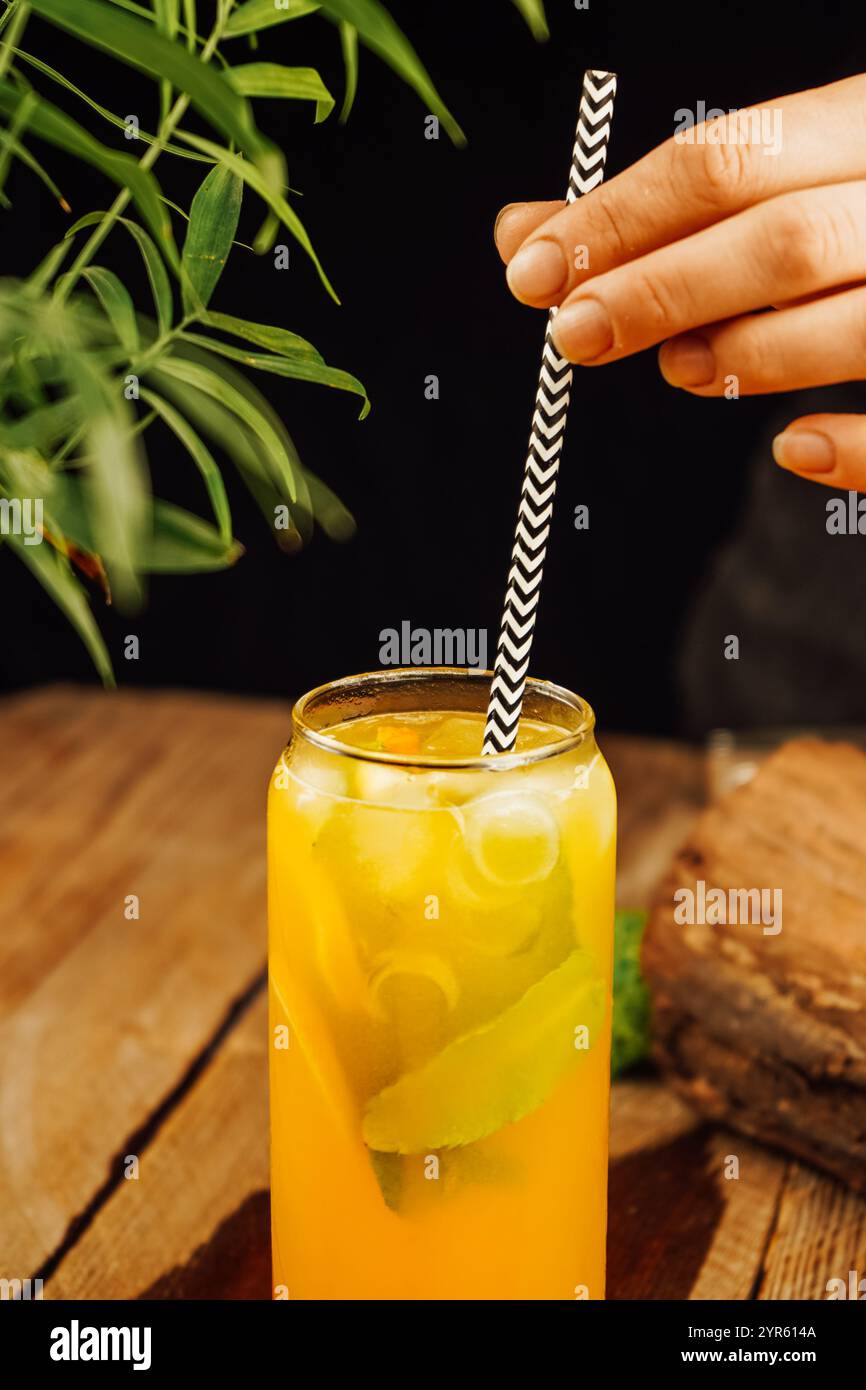 Zesty lemonade glows with vibrant citrus slices and ice. The dark ...
