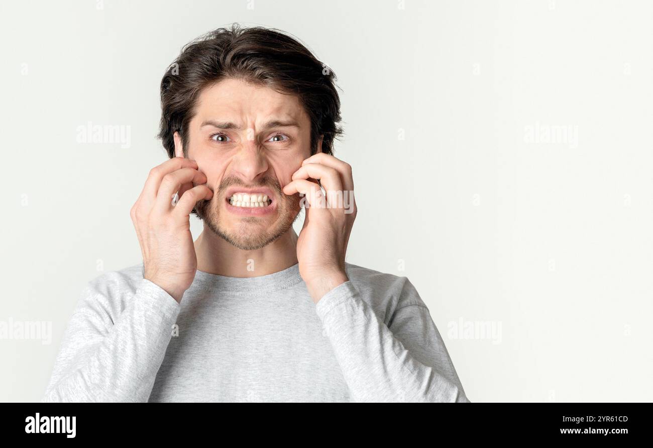 Allergy concept. Millennial man scratches his cheeks Stock Photo - Alamy