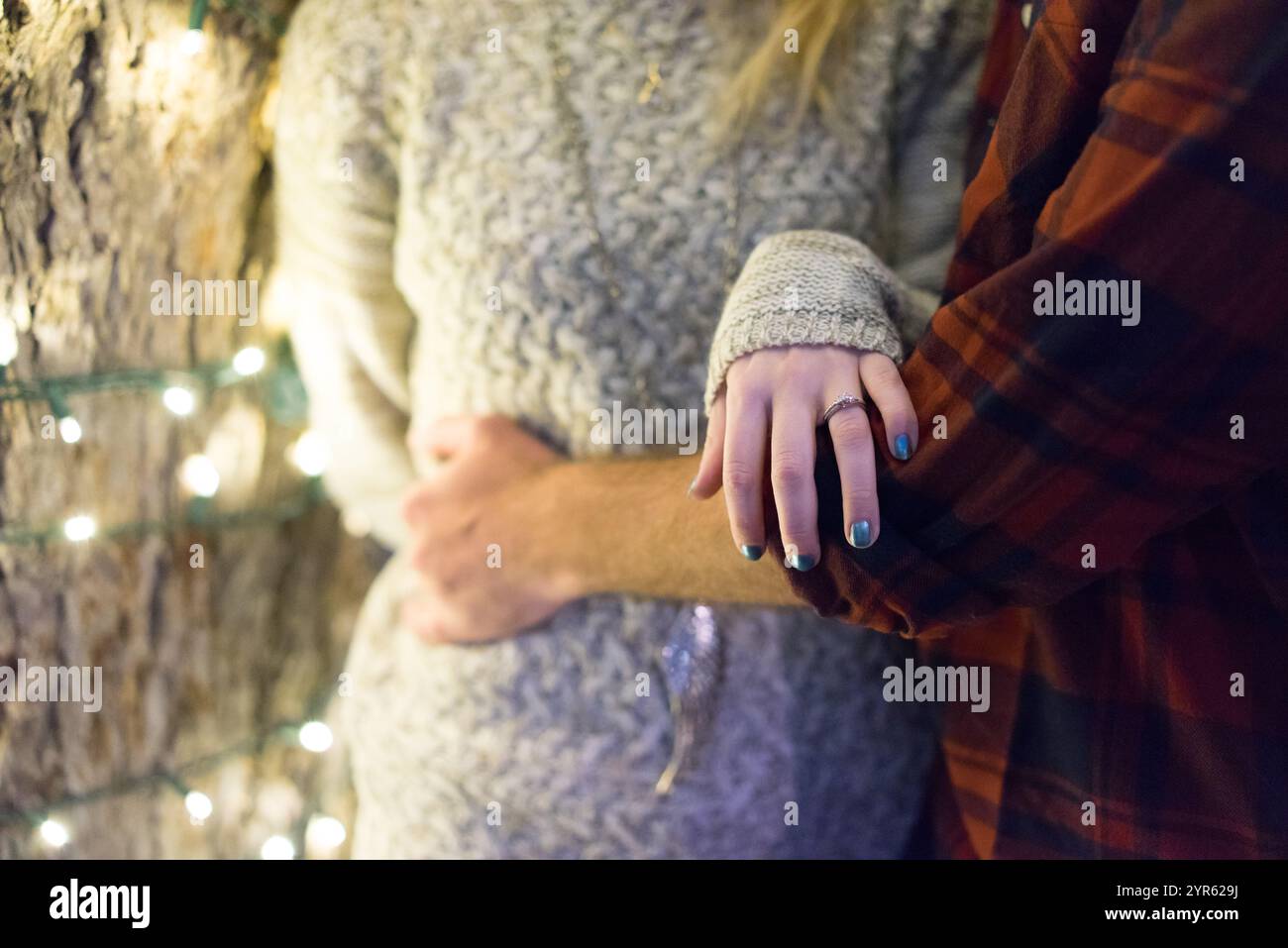Romantic Couple Embracing in Winter Knitwear with Engagement Ring ...