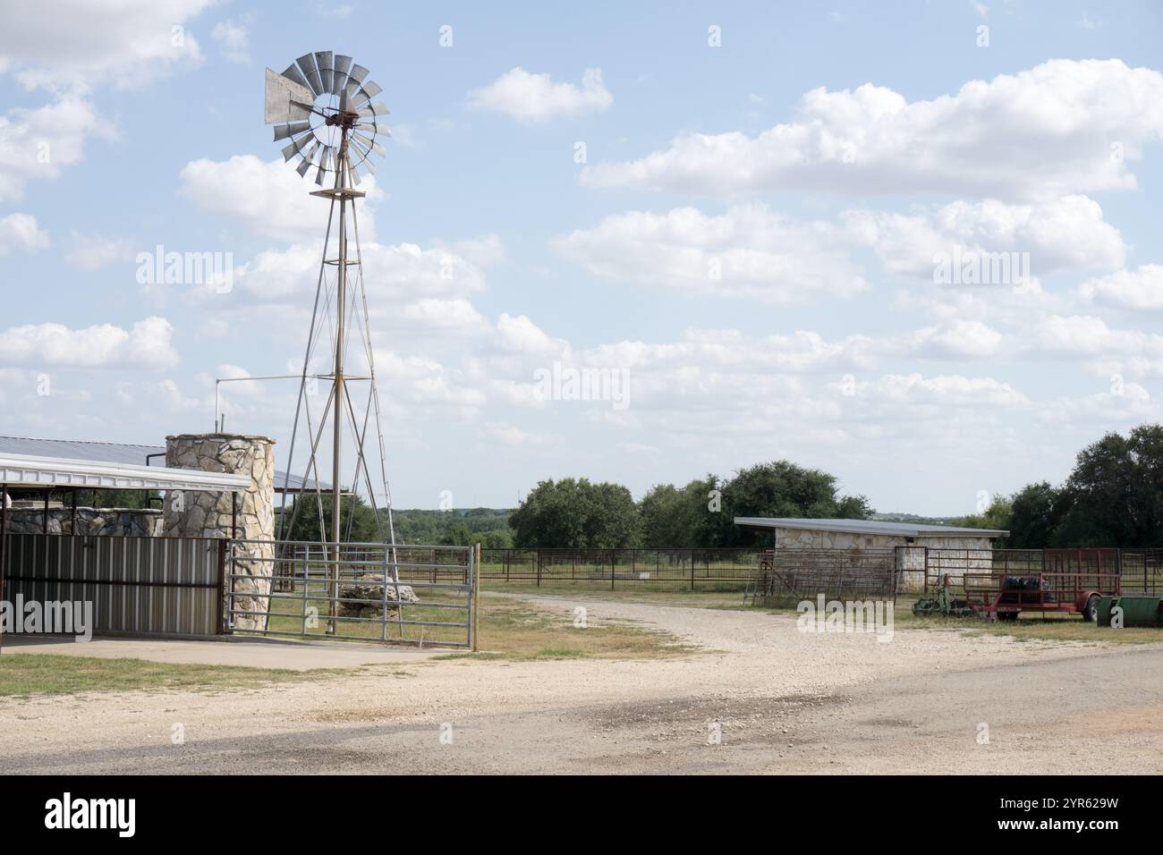 Rural Farm Landscape with Windmill and Stone Structures Under Blue Sky ...