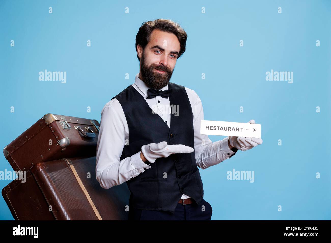 Hotel porter uses restaurant wall sign to help people with directions ...