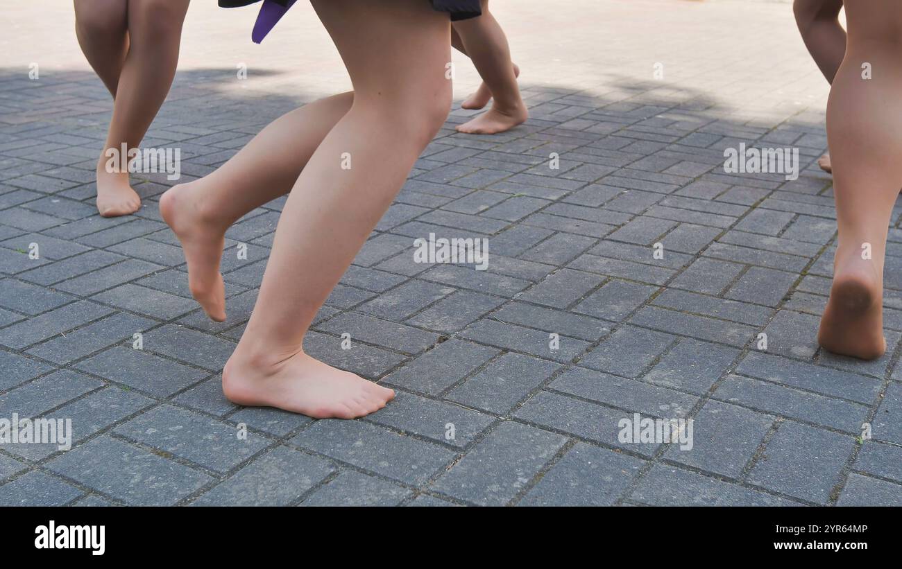 Students celebrating end of school year, walking barefoot on pavement ...