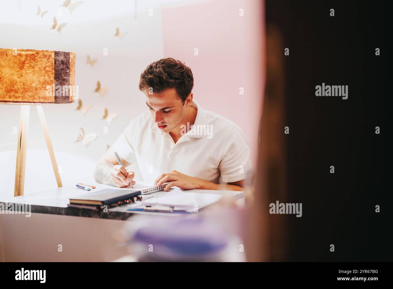 Focused college student studying at home in a cozy setting Stock Photo ...