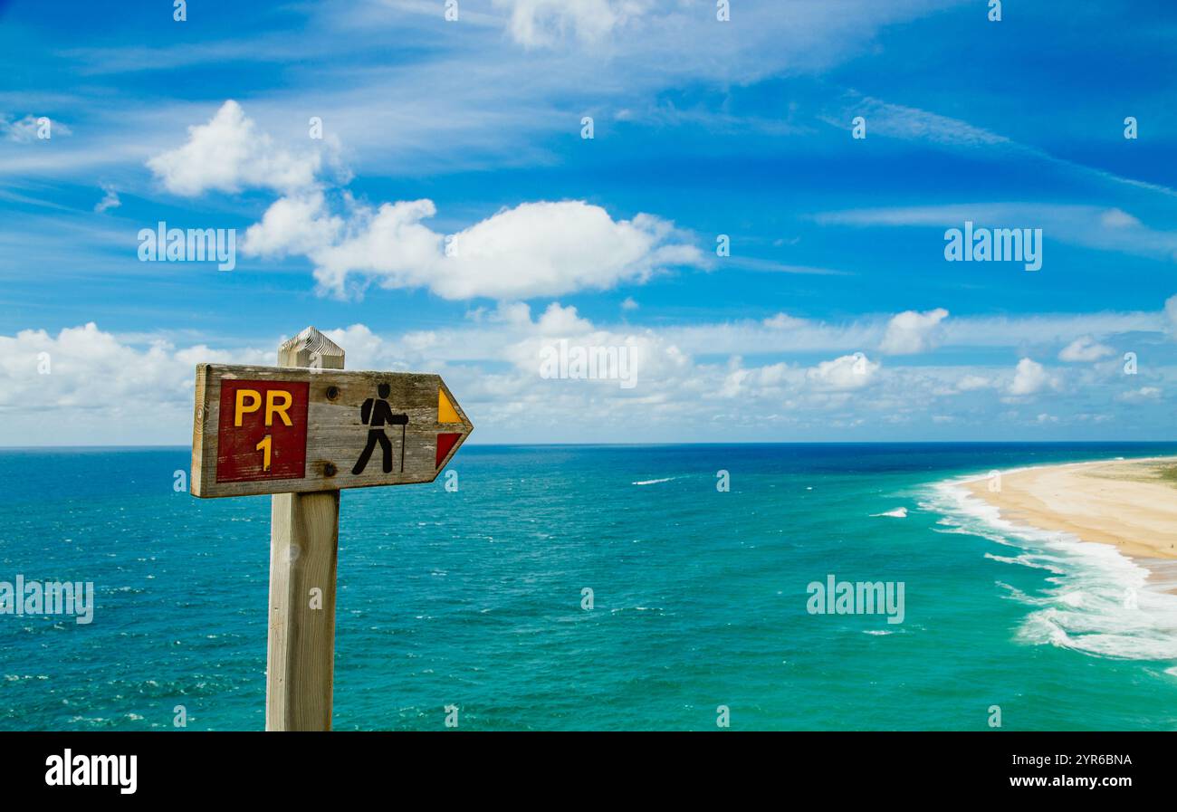 Wooden hiking trail sign pointing towards the beautiful beach and ocean ...