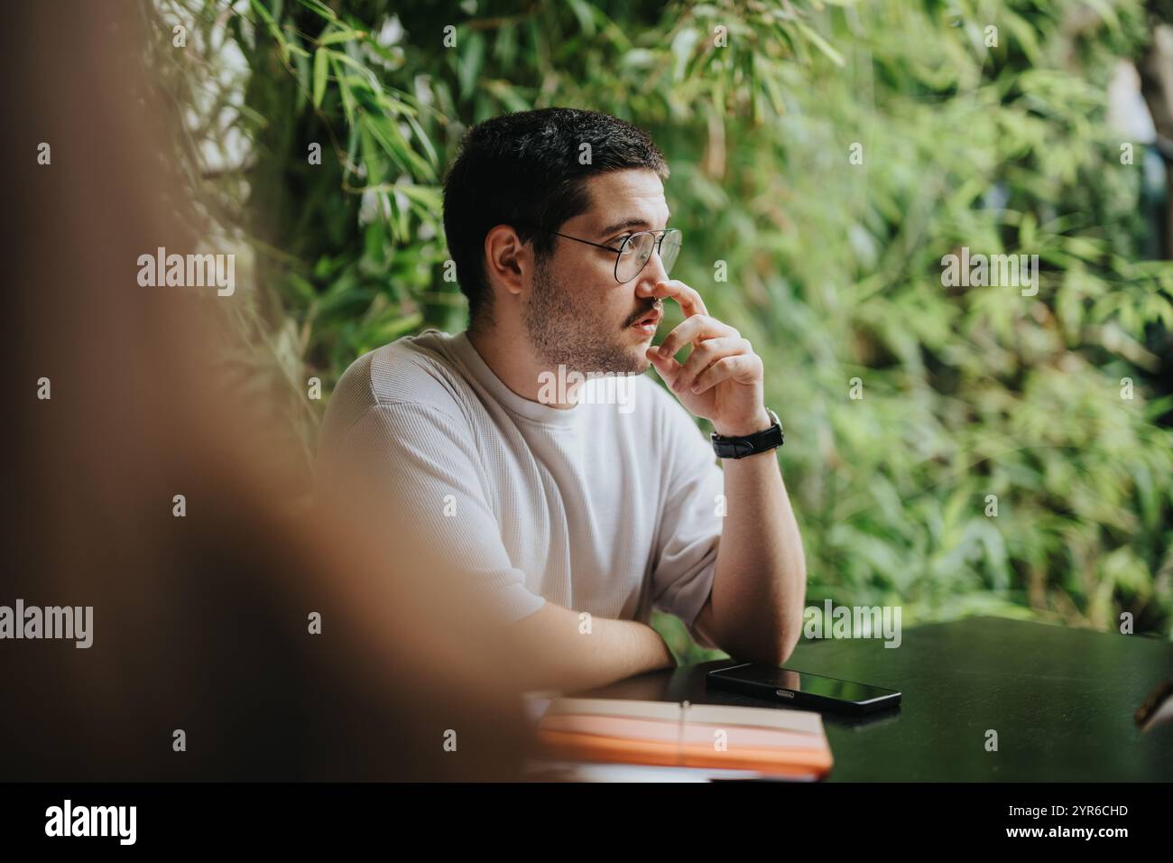 Thoughtful student studying in a relaxed coffee shop environment Stock ...